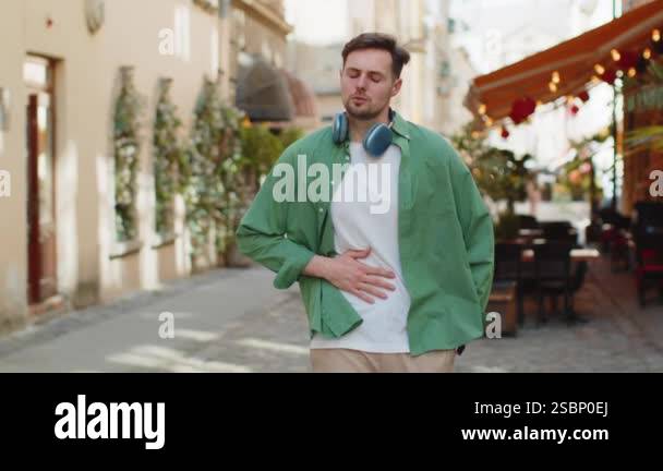 Caucasian young man traveler feeling sudden strong abdominal stomach ...