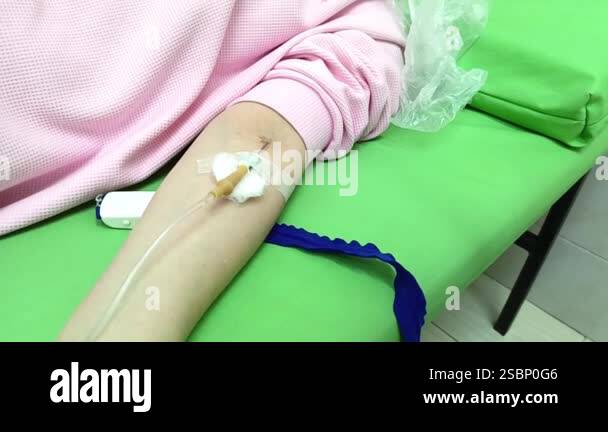A woman's hand with an IV drip. An IV catheter in a woman's arm ...