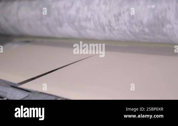 Cut cardboard sheets pass through mechanism to level surface in ...