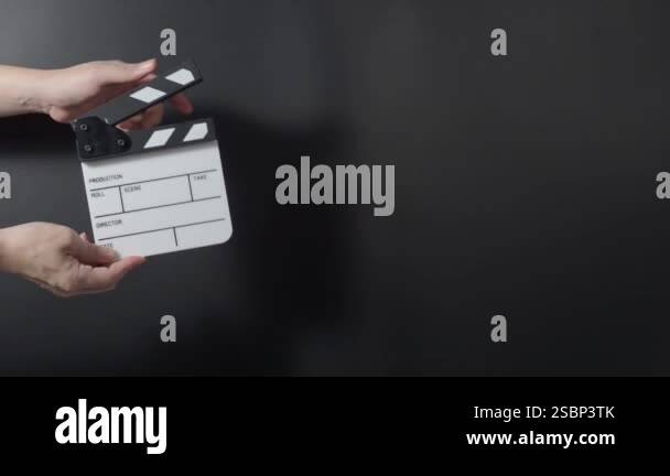 A classic film clapperboard or film slate being held and hit against a ...