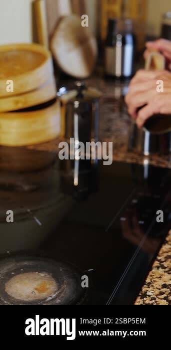 Close-up of hands filling a moka pot with ground coffee and placing it ...