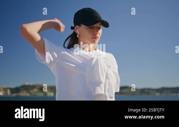Fit girl warming up muscles at morning sport training on quay closeup ...