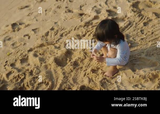 toddler baby girl play with shell on the sea beach in Pattaya, Thailand ...