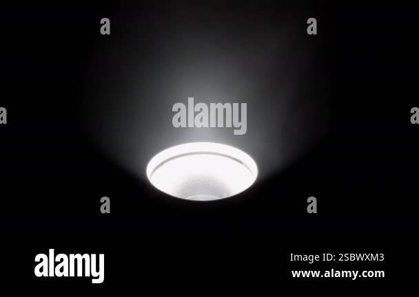 Ceiling light fixture illuminating in a dark room, Close-up of a ...