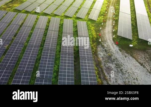 Aerial 4K view of solar panels installed on a landscaped field ...