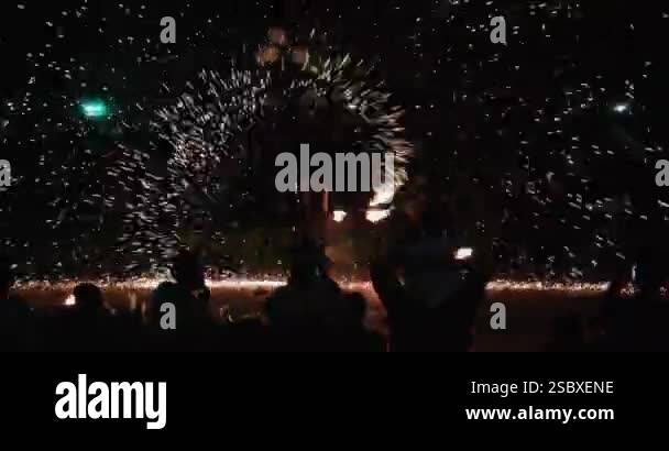 Fire performance show, red sparks at night. Female artist spins sparklers at the street. Fire ...