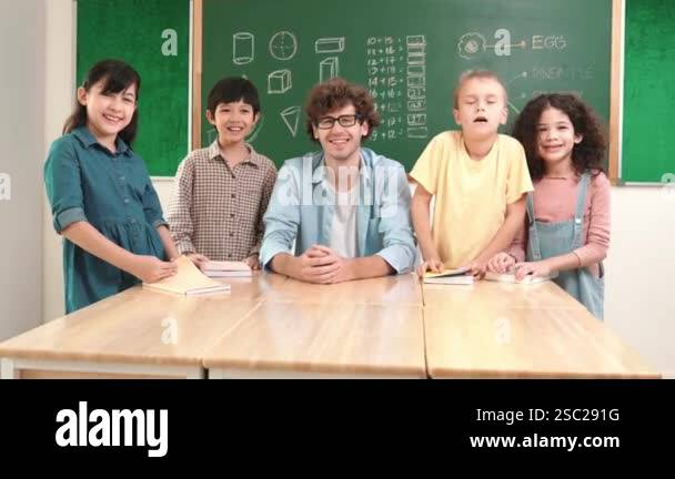 Professional caucasian teacher and diverse student looking at camera while happy boy giving ...