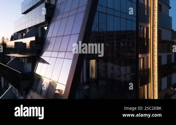 A modern high-rise building with glass balconies and illuminated ...