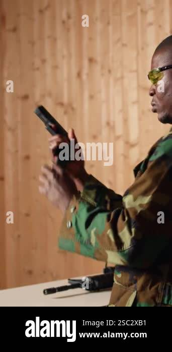 Vertical video Soldier in shooting range reloads pistol, shooting ...