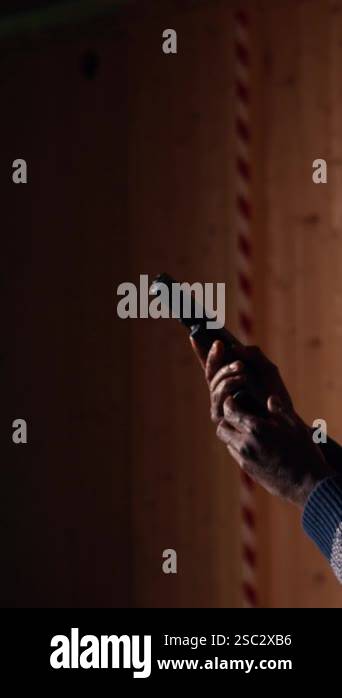 Vertical video Person wearing safety goggles loading pistol bullets ...