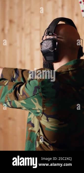 Vertical video Army soldier in shooting range reloads pistol, shooting ...