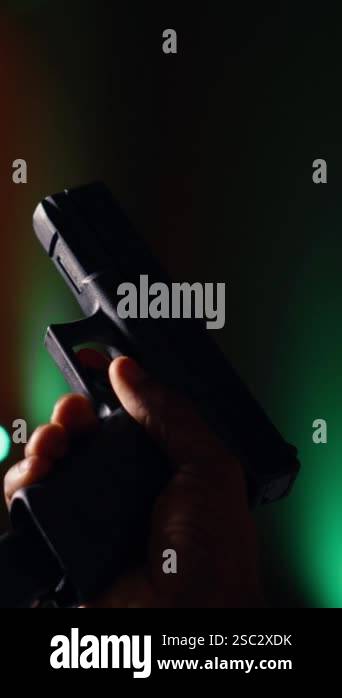 Vertical video Man reloading handgun in indoor shooting range ...