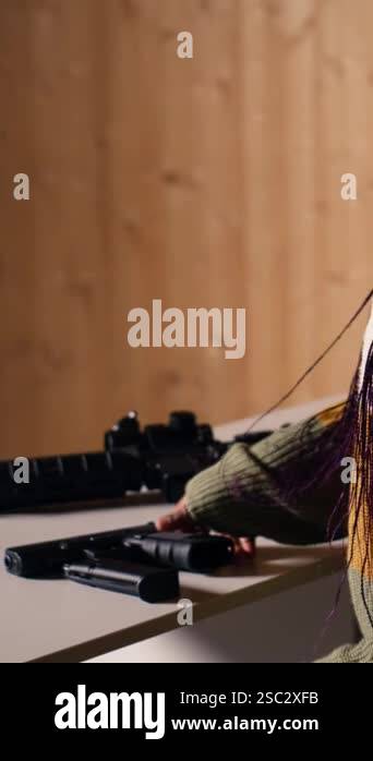 Vertical video Person wearing safety equipment loading bullets ...