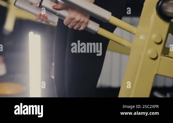 Close-up of a girls hands holding the handles of an exercise machine. A ...