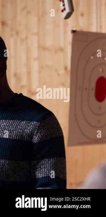 Vertical video Shooting range safety officer demonstrating how to ...