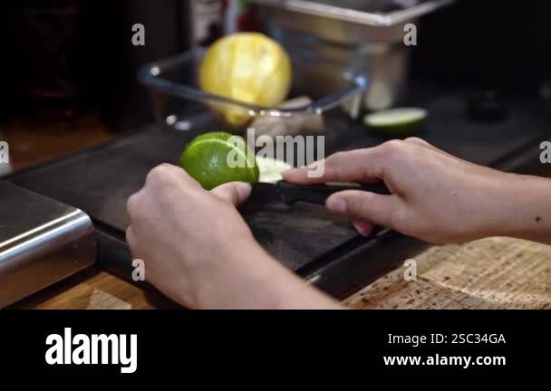 Slicing lime with precision, hands preparing fresh citrus for vibrant ...