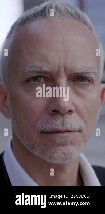 Vertical. Close up serious mature business man looking earnest at ...