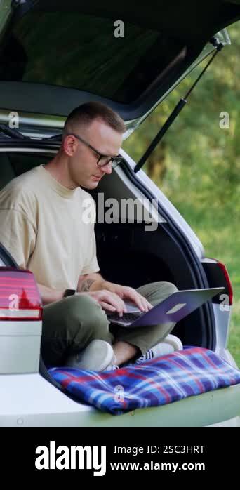Freelancing man works on his laptop. Entrepreneur works outdoors ...