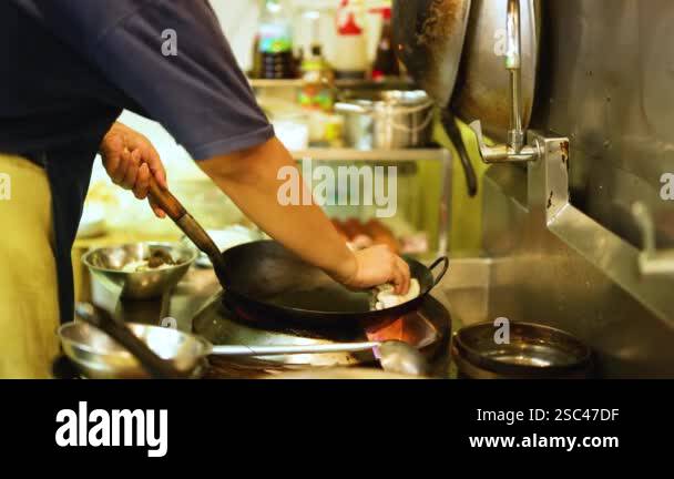 Chef skillfully cooks with a wok in kitchen Stock Video Footage - Alamy