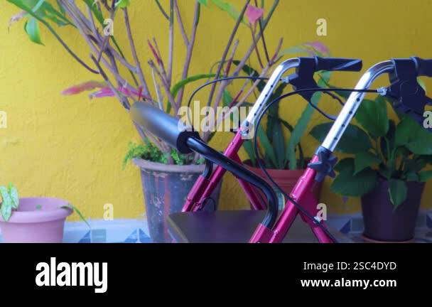 Walker with brake levers with seat with elderly woman holding handle to ...