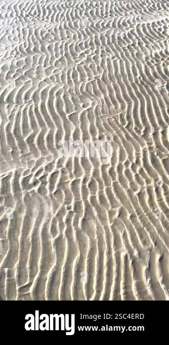 Ocean shapes sand patterns, beach texture forms wavy lines, wind ...