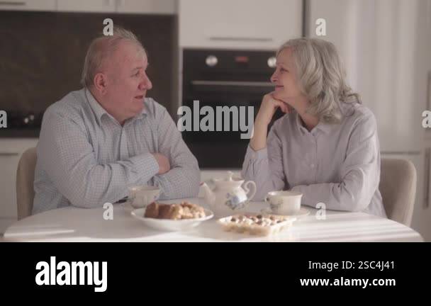 Elderly couple enjoying tea and pastries in their kitchen Stock Video ...