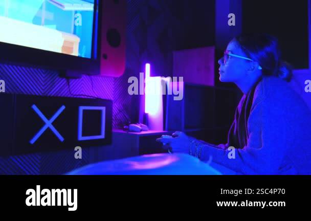 A woman is playing a video game on a Playstation 4. She is wearing ...