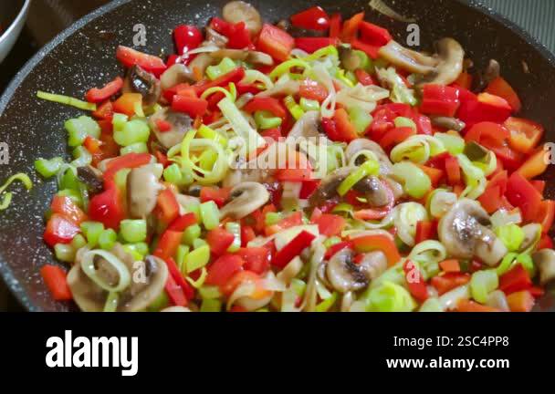 Food preparation. Adding black pepper to food. Various vegetables are ...