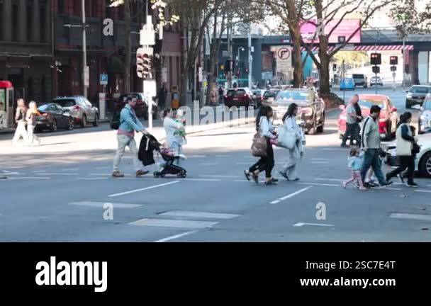 Pedestrians crossing road, cars waiting at intersection Stock Video ...