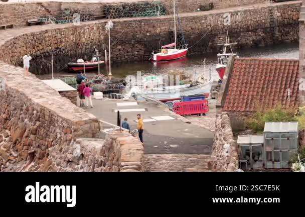 Tourists exploring a scenic port in Fife Stock Video Footage - Alamy