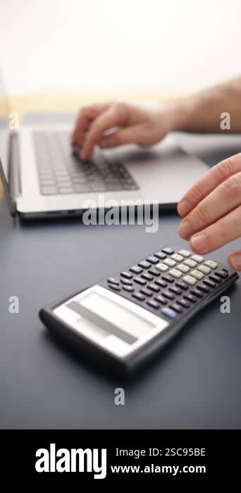 man uses calculator and laptop daily at work. modern technologies and ...