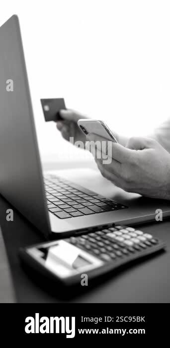 black and white video. man enters bank card details into phone and makes online purchases via ...