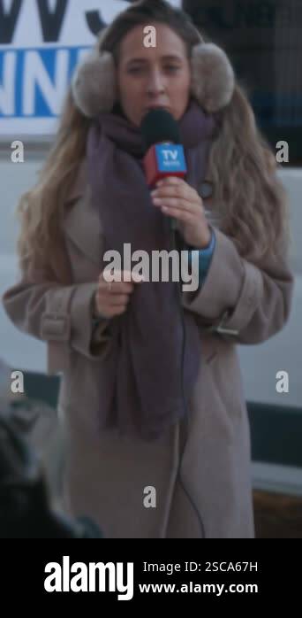 Medium vertical shot of screen of video camera, filming female reporter ...