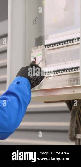An African American electrician wearing a hard hat and safety vest ...