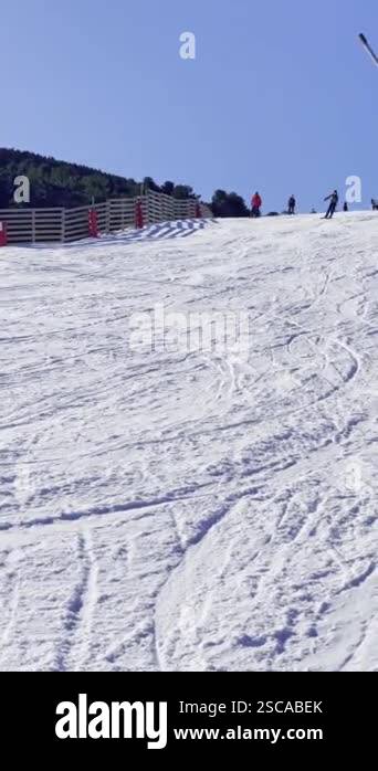 Skiers slalom down a snowy slope at the Valdelinares ski resort in ...