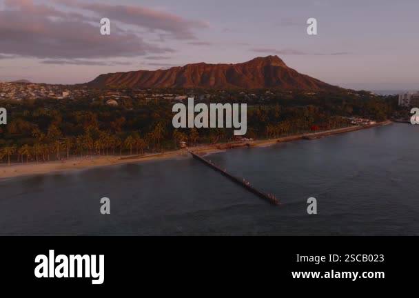 Aerial sweep of Waikiki Beach in Oahu during sunset, featuring Diamond ...