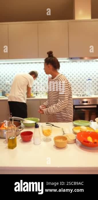 A happy couple joyfully cooking in their stylish kitchen, savoring a ...