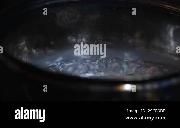 boiling water being poured into a heated pot, momentarily stopping the ...