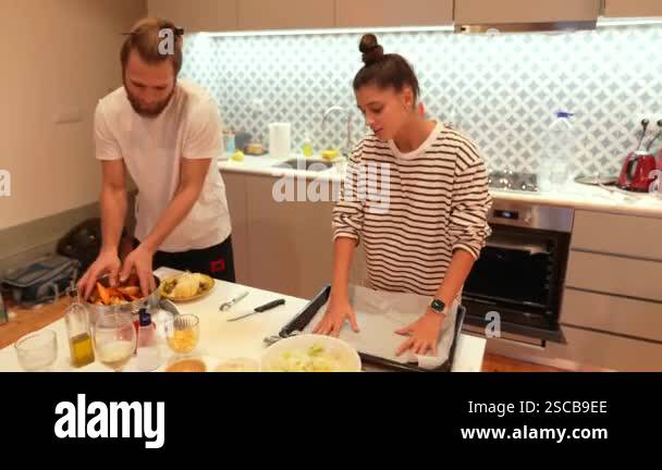 Two people are happily cooking delicious food together in a modern ...