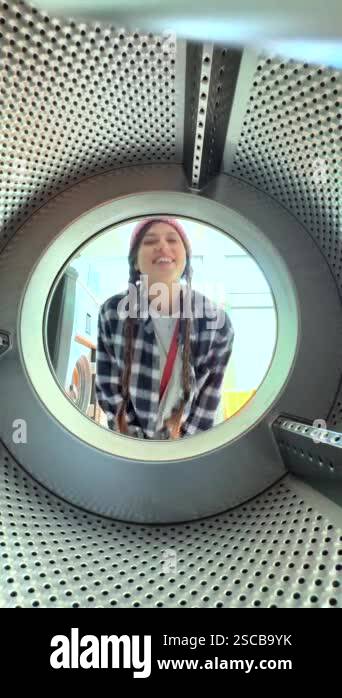 A person curiously peeks through the dryer, capturing an expression of ...