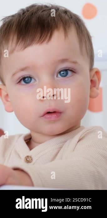 Portrait of a happy and curious Caucasian little baby boy, sitting in ...