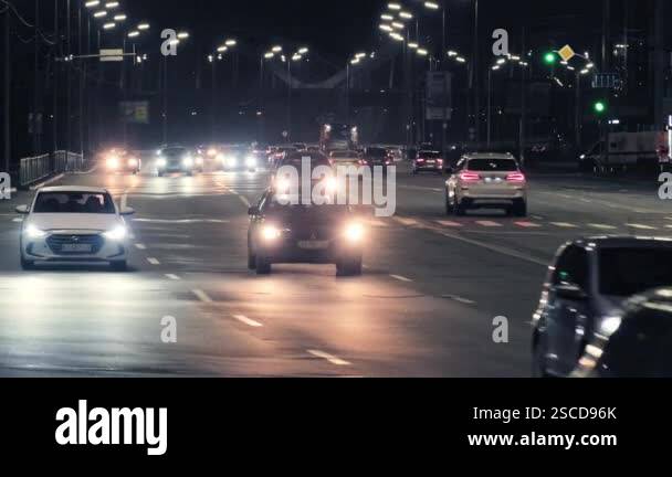 A vibrant nighttime urban scene with busy streets, bustling traffic ...