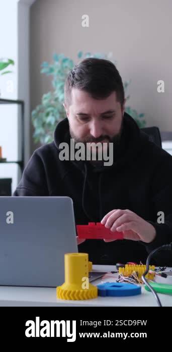 Caucasian focused male designer or technician examining 3D printed ...