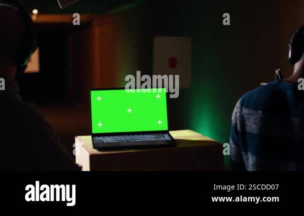 Green screen laptop in shooting range next to man successfully shooting ...