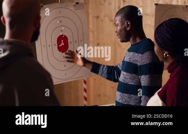 Shooting range safety officer explaining bullseye scoring system to ...