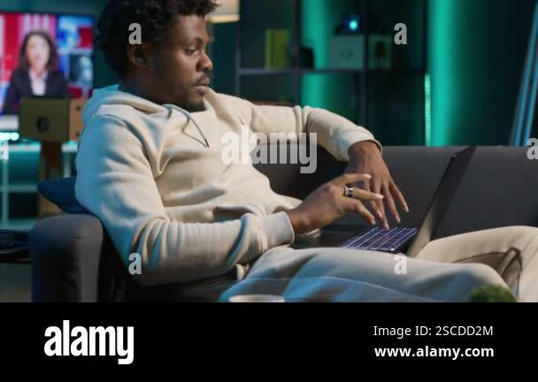 African american person navigating the internet on laptop at his modern ...