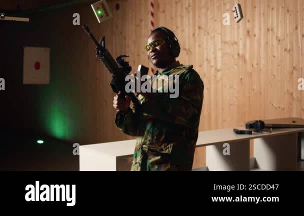 Portrait of cheerful soldier doing training in shooting range ...