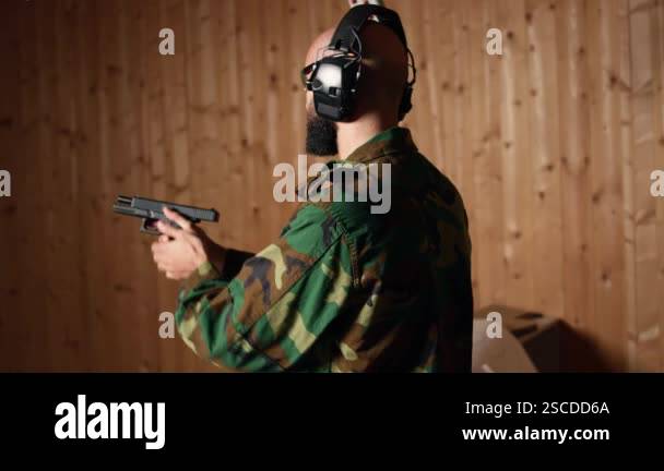 Man in firing range shooting targets with pistol doing face palm after ...