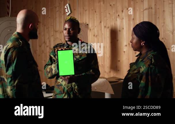 Team of military units at shooting range watching video on green screen ...