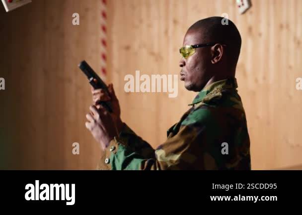 Soldier in shooting range reloads pistol, shooting target, celebrating ...